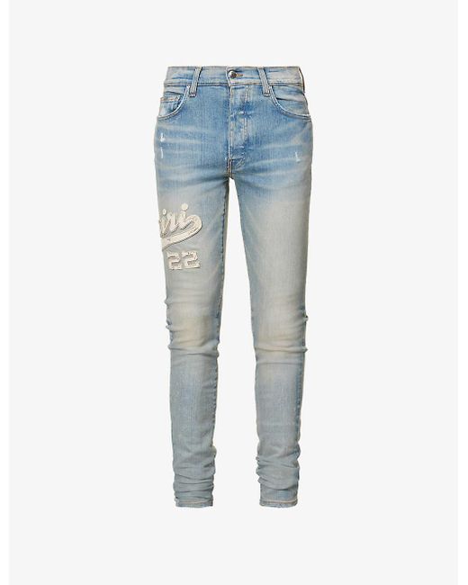 Amiri Varsity Logo-appliqué Slim-fit Tapered-leg Stretch-denim Jeans in ...